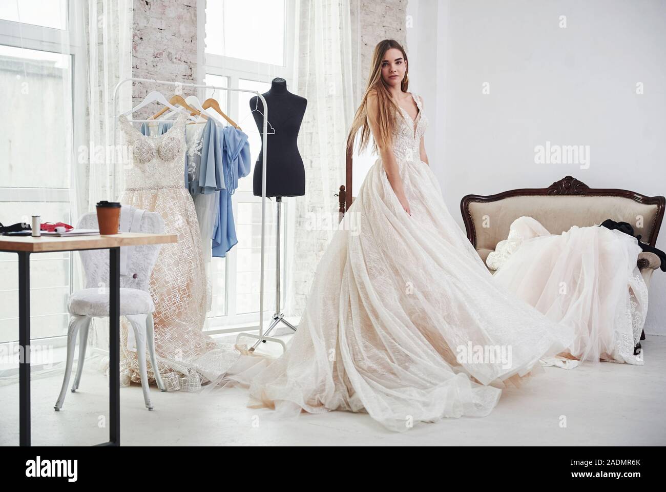 Beautiful blonde. The process of fitting the dress in the studio of ...