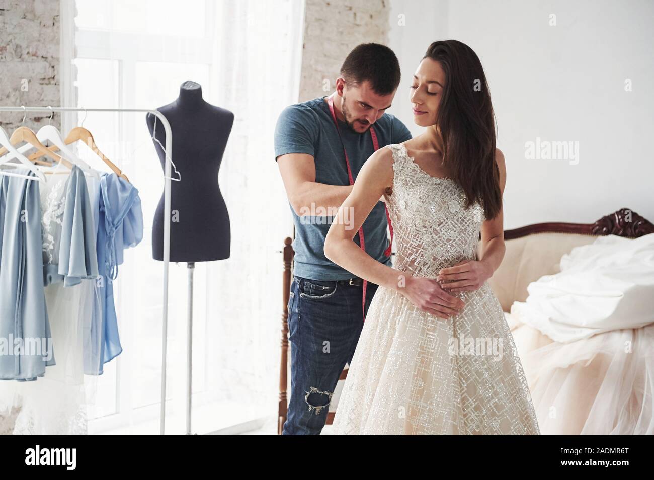 Man is helping the bride. The process of fitting the dress in the ...