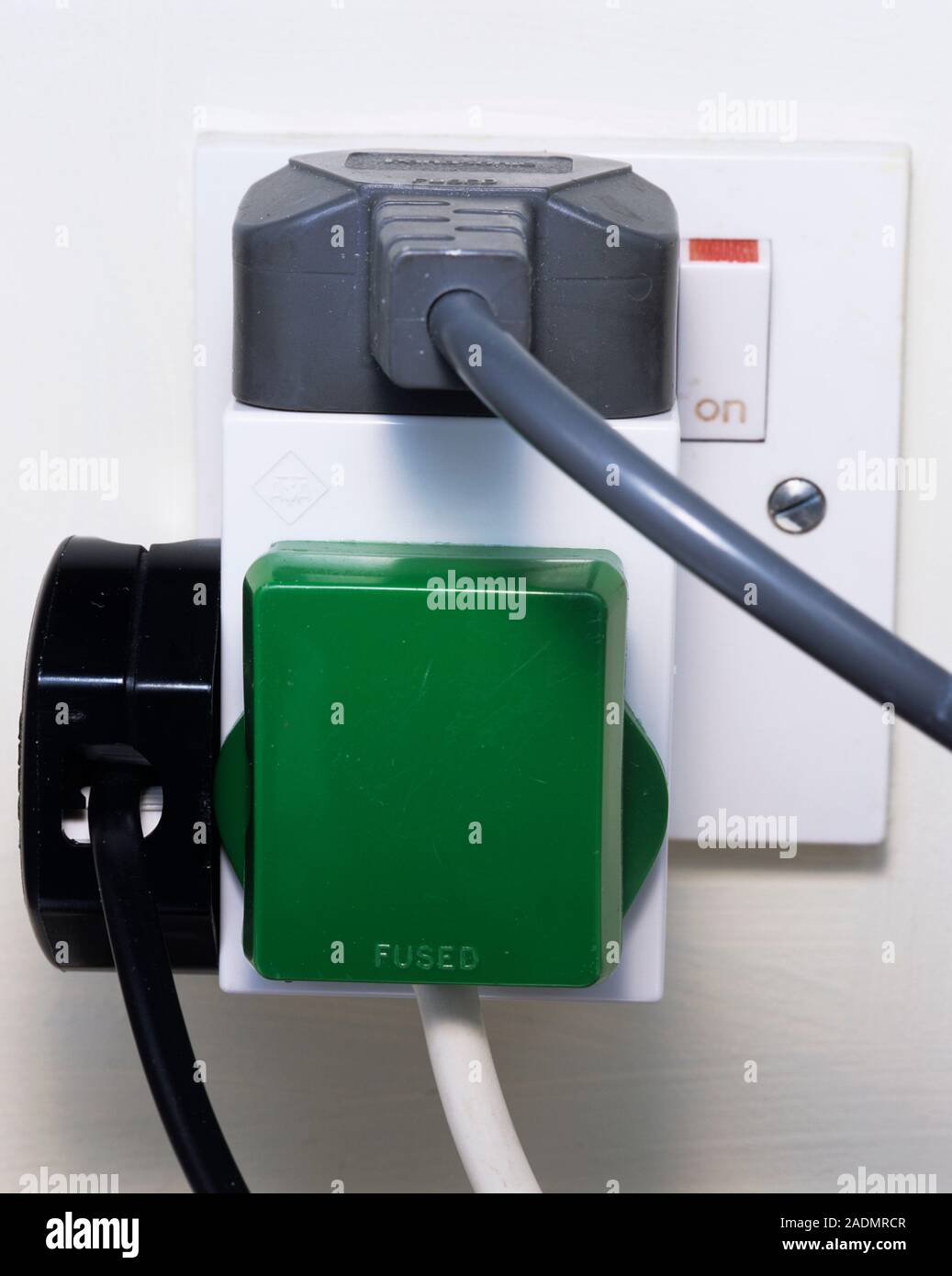 Heavily loaded plug socket. A three-way adapter has been attached to ...