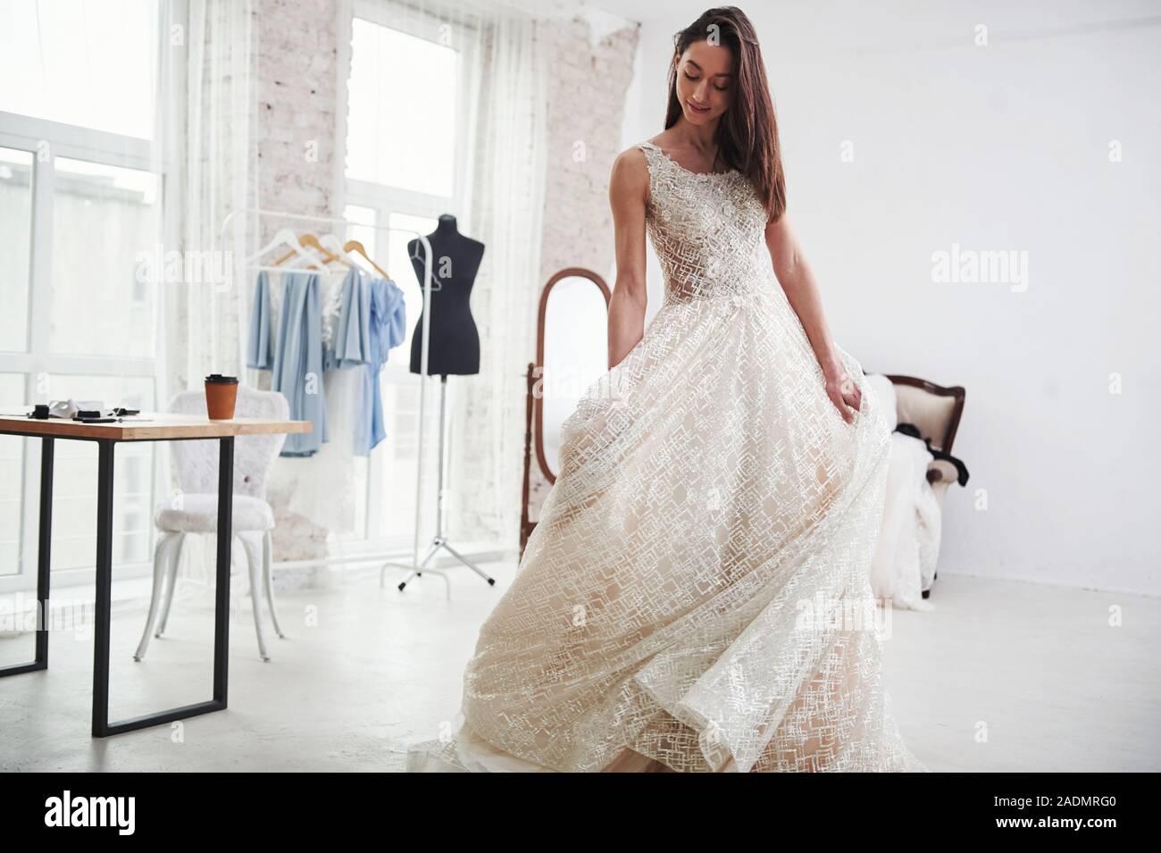 Gorgeous brunette is satisfied. The process of fitting the dress in the ...