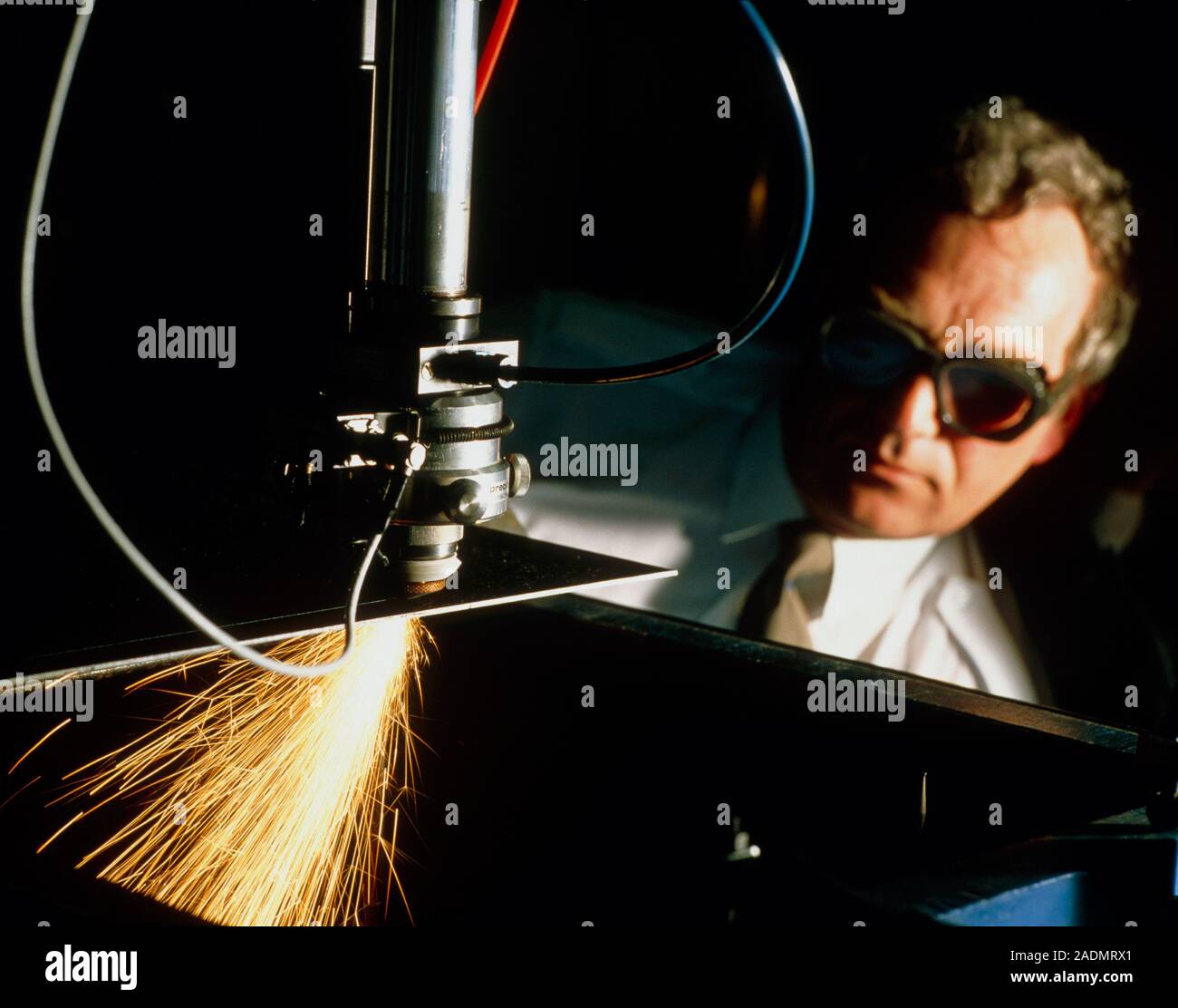 Laser cutting. Operator wearing safety glasses observes a carbon ...
