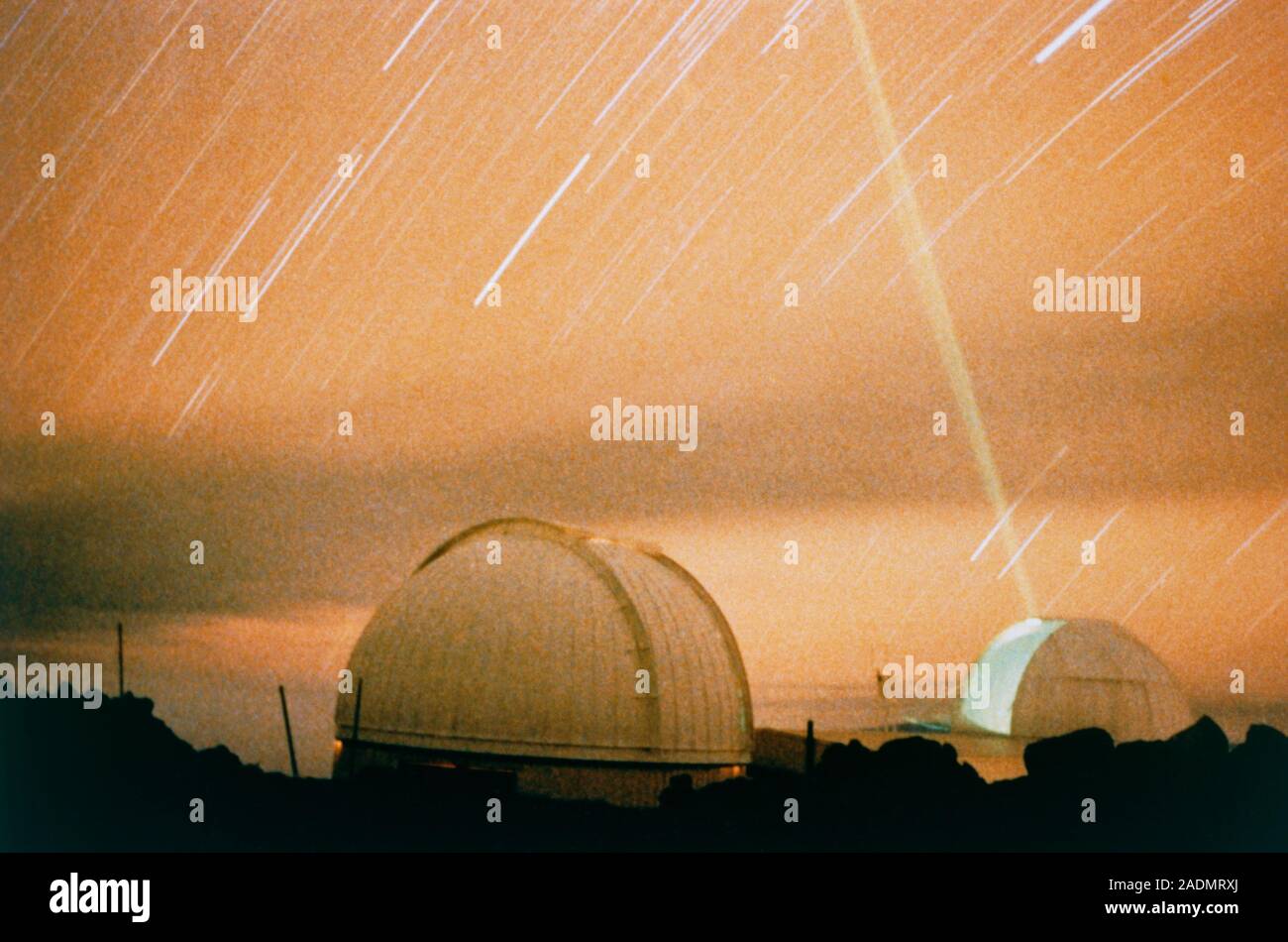 A laser beam is fired into the night sky from an observatory on the ...