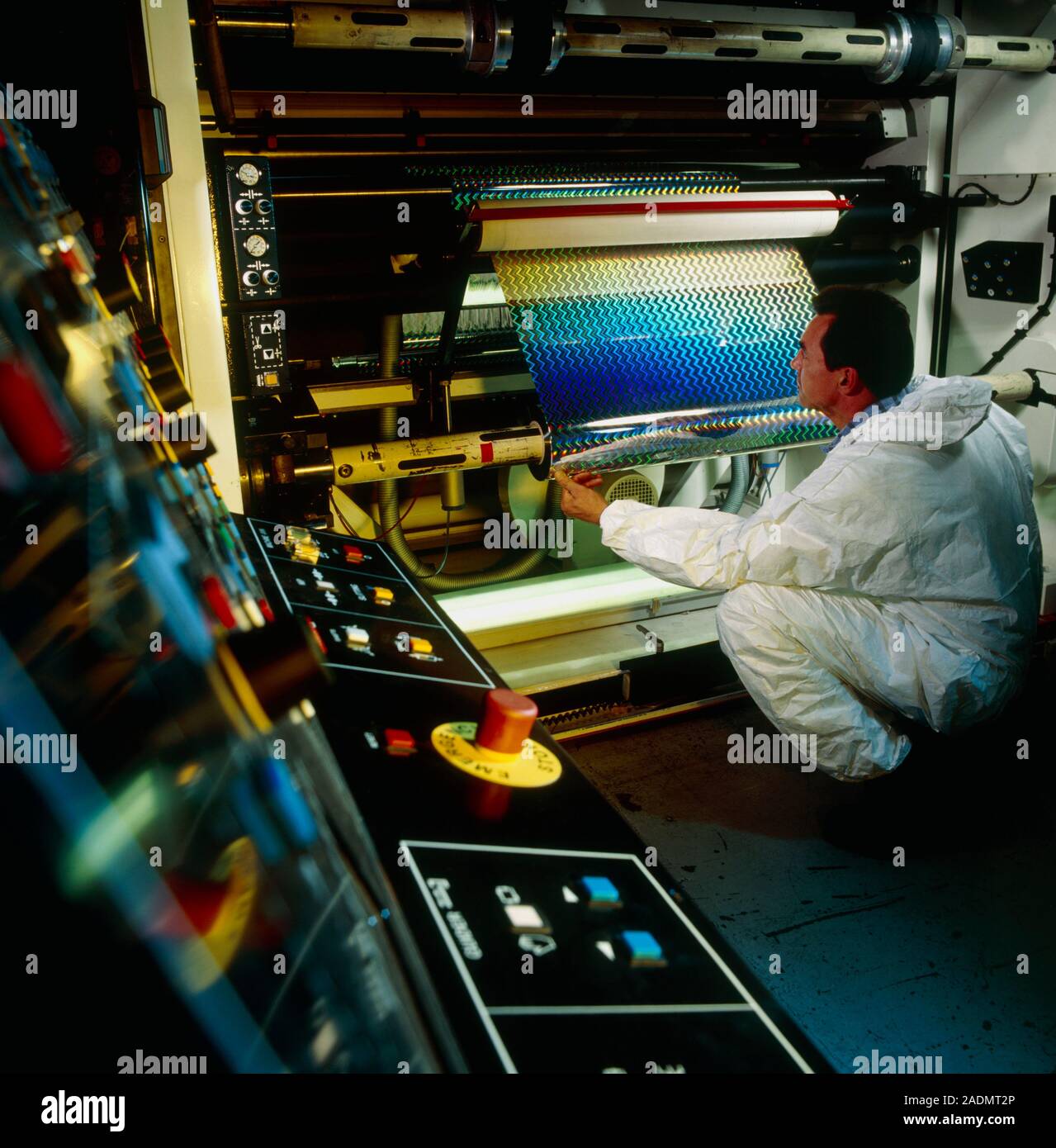 Holographic material. Technician carrying out visual quality control on ...