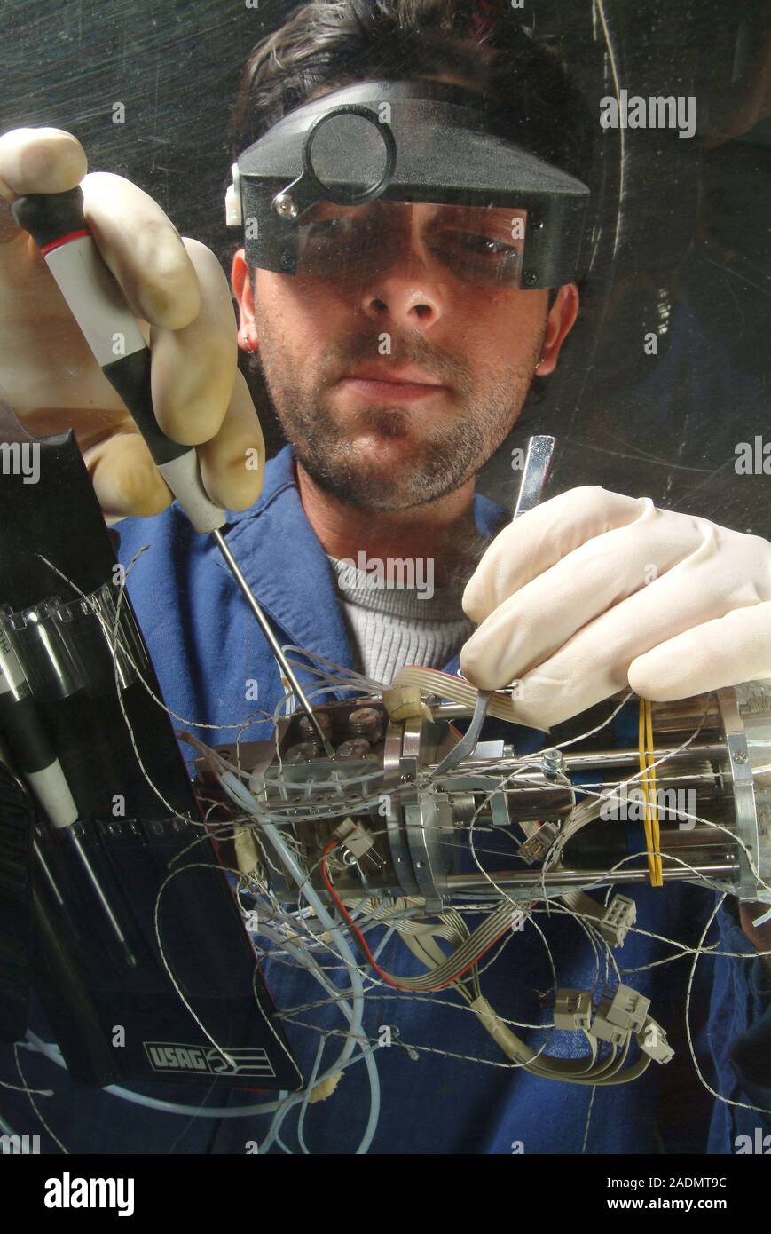 Robot construction. Technician using tools to construct part of a robot ...
