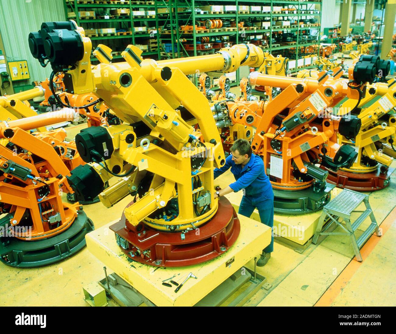 Robot assembly. Technician assembling an industrial robot, surrounded ...