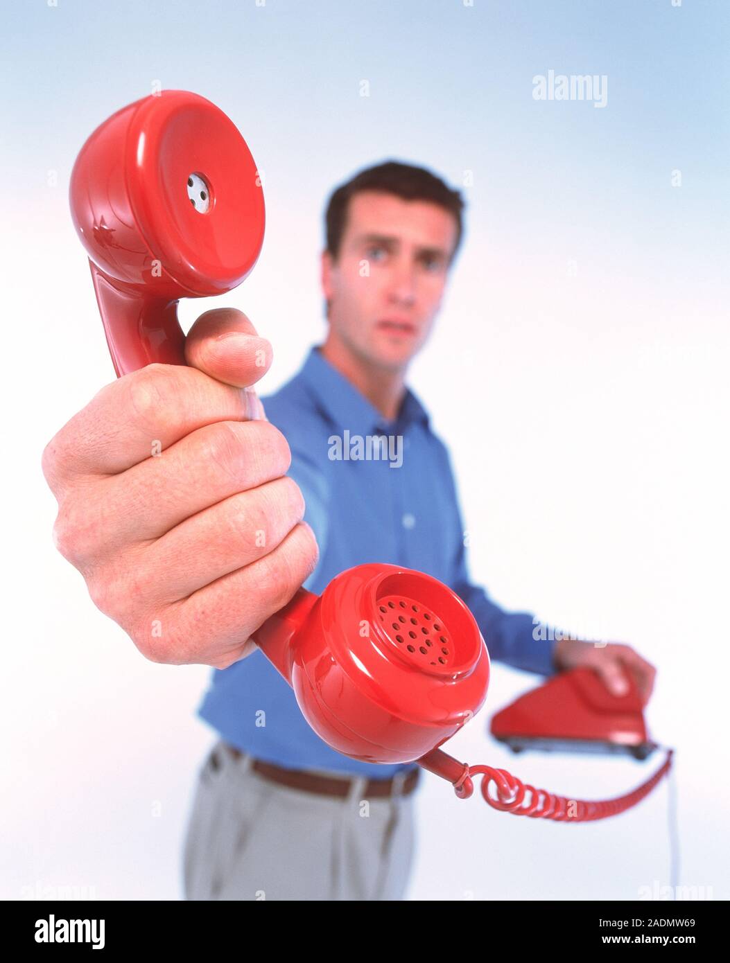 It's for you. Man holding a telephone receiver in his outstretched arm ...