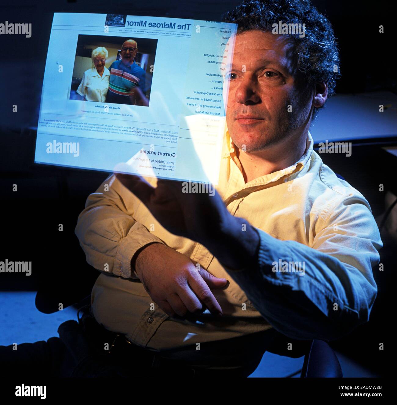 Electronic newspaper. Man using a touch-screen to select articles from ...