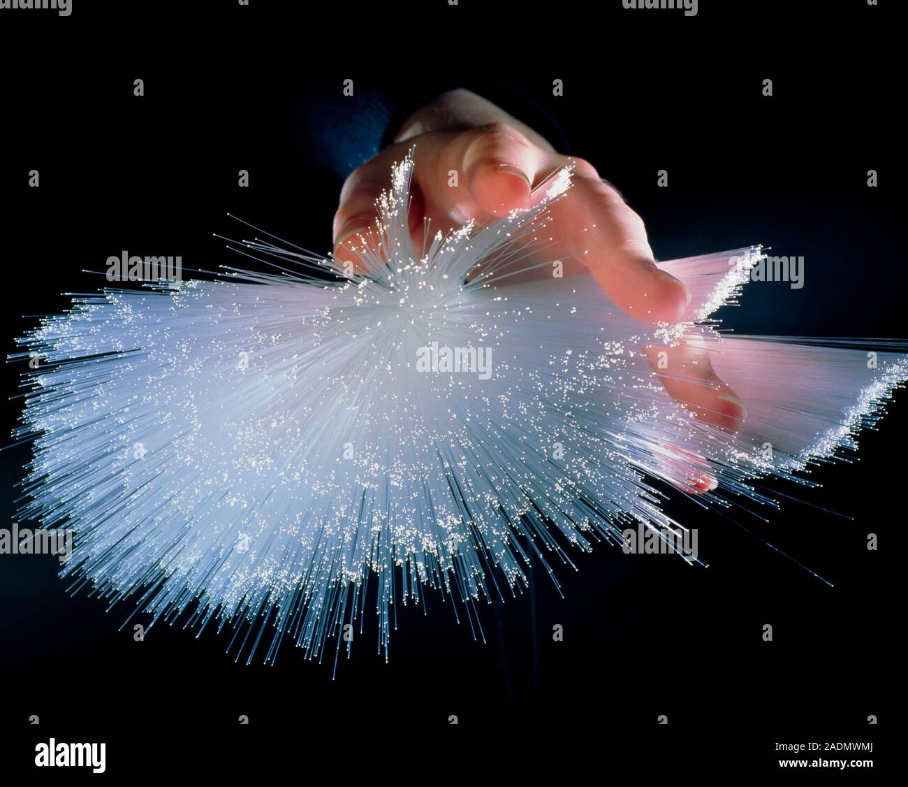 Fibre optics. Fingers weave through optical fibres which are conducting ...