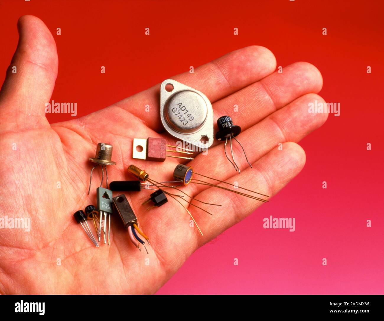 Transistors. Hand holds an assortment of transist- ors from the 1960s ...