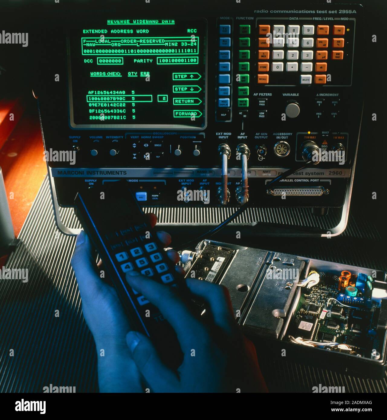 Mobile telephone testing. Technician's hands performing a test on a ...