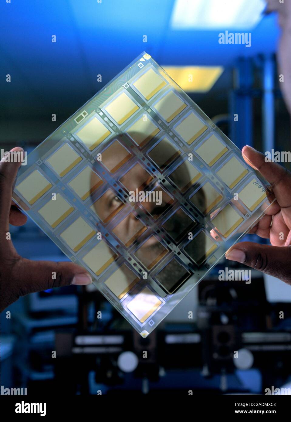 Organic light emitting diode. Researcher's face reflected in a panel of ...