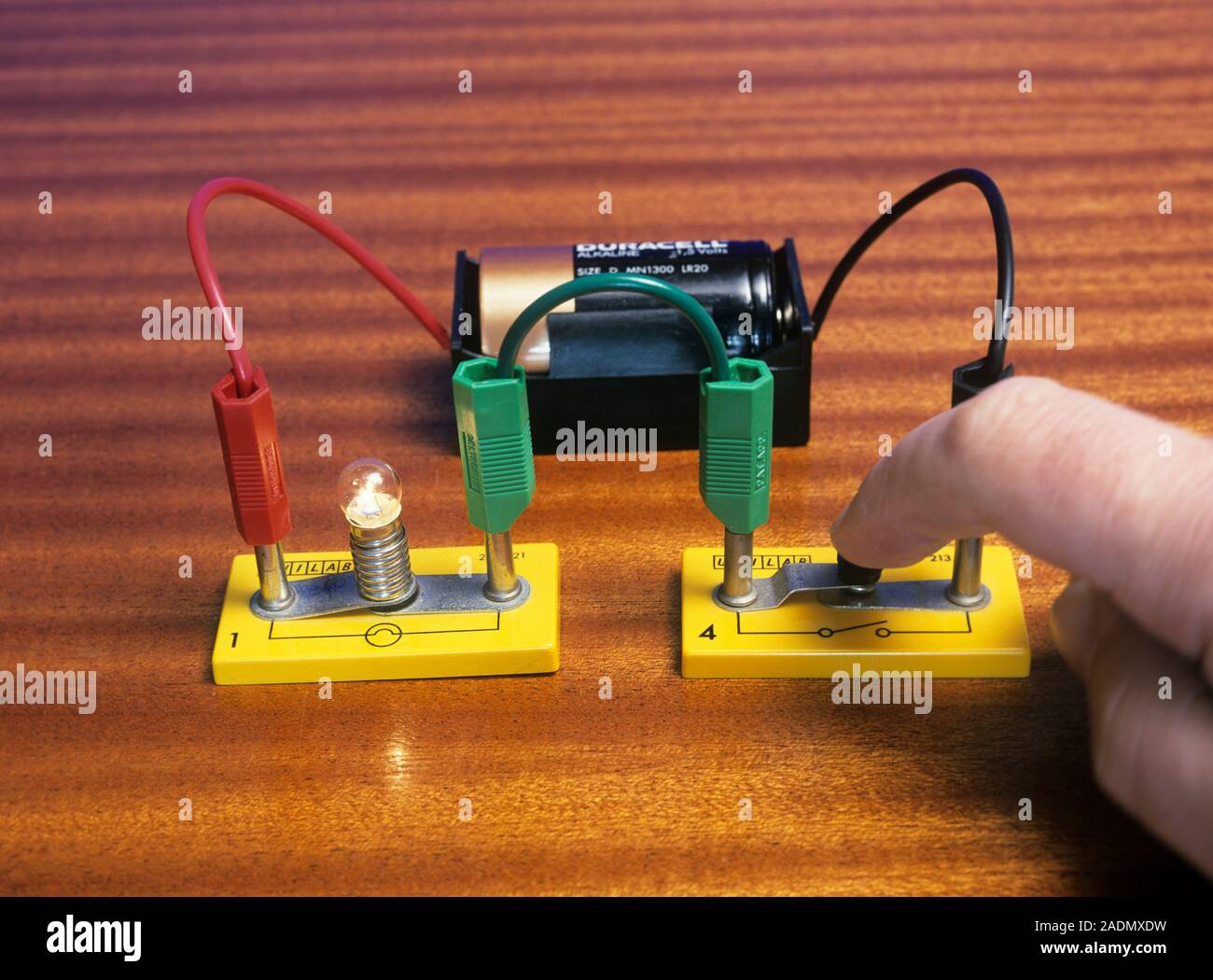 Electrical circuit. Switch being held closed (at right) to complete an ...