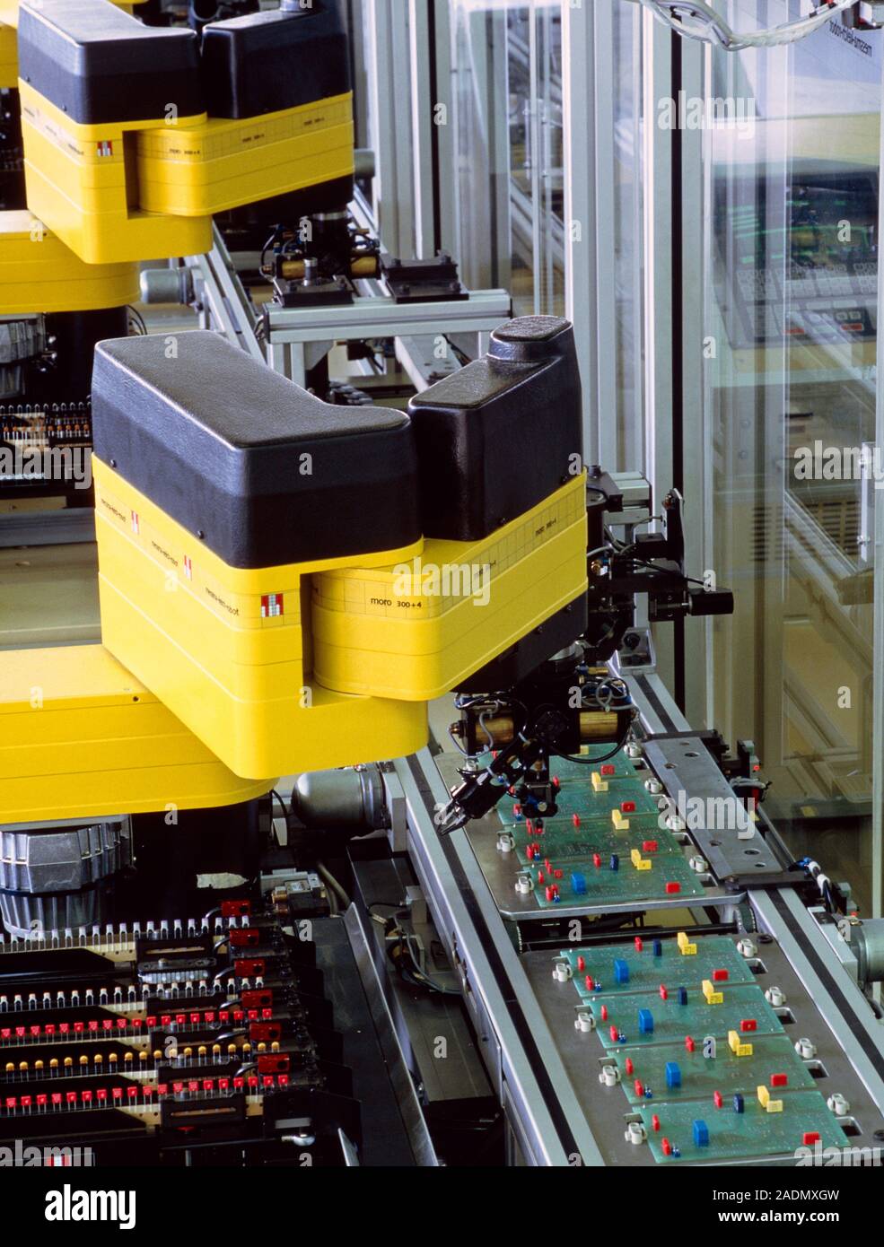 Circuit board manufacture. Yellow robots manufac- ture electronic ...