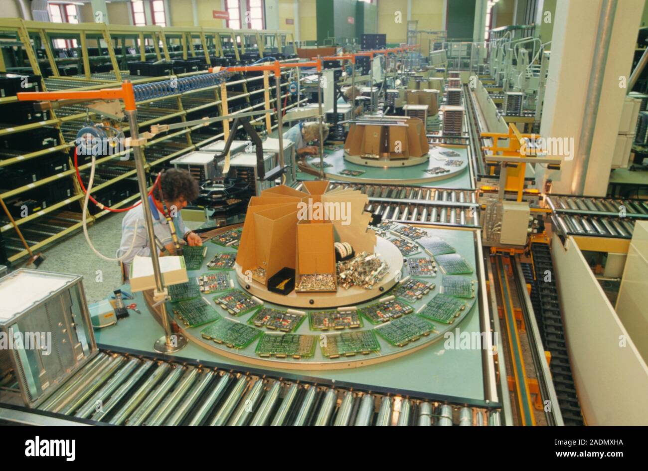 Circuit board manufacture. Workers constructing printed circuit boards ...