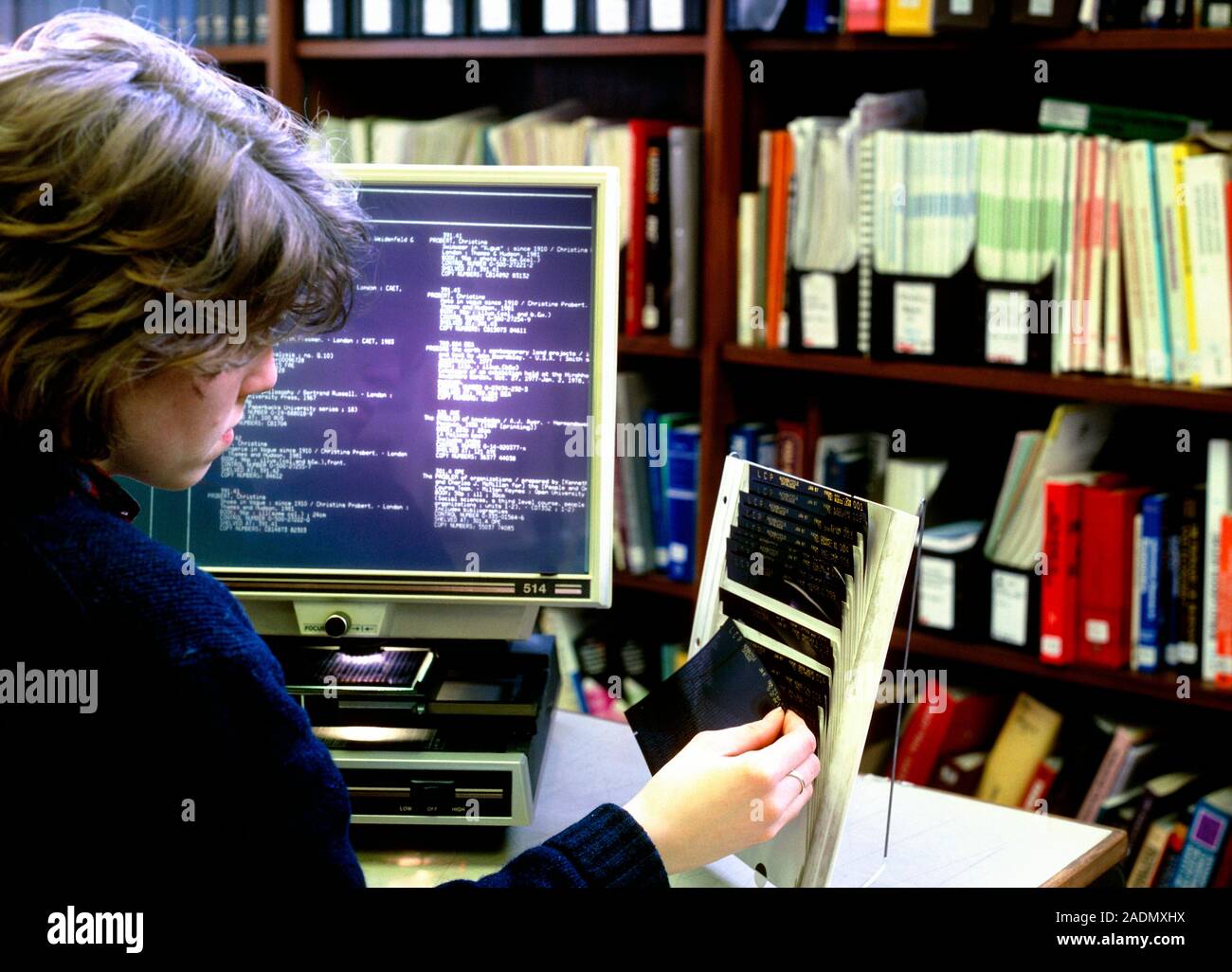 Young woman using the micofiche index at a London lending library ...