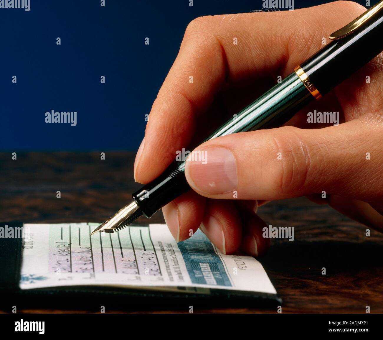 Cheque. Hand writing a cheque with a fountain pen Stock Photo - Alamy