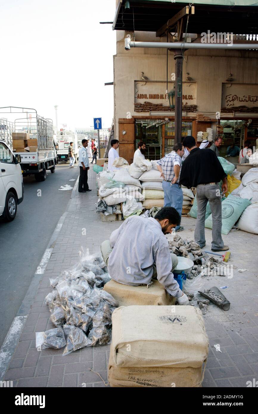 Spice trader breaking up, weighing and bagging fresh spices ready for ...