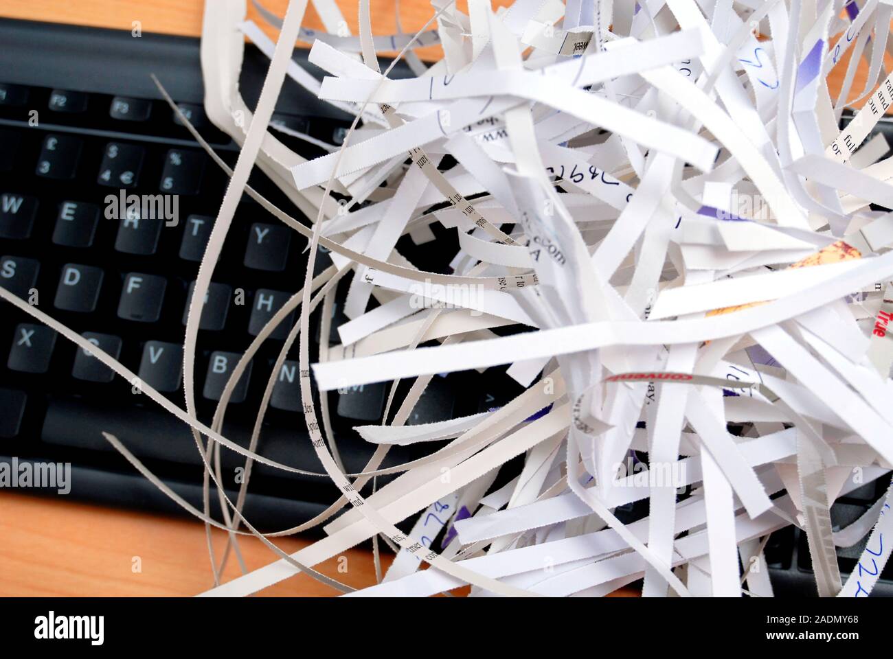 Shredded office paper on a desk next to a computer keyboard. Personal ...
