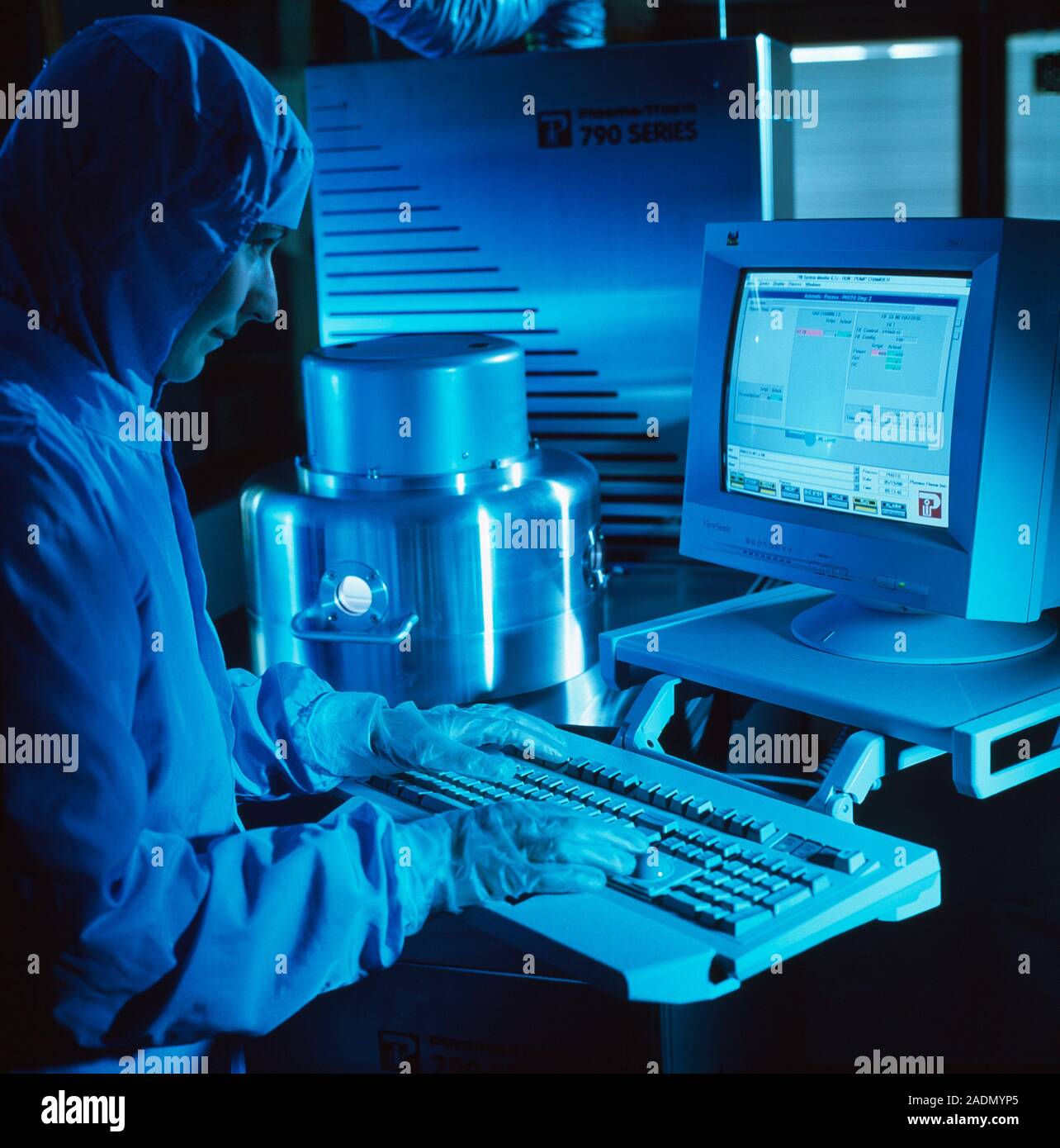 Plasma etching. Technician in clean room clothing controlling the ...