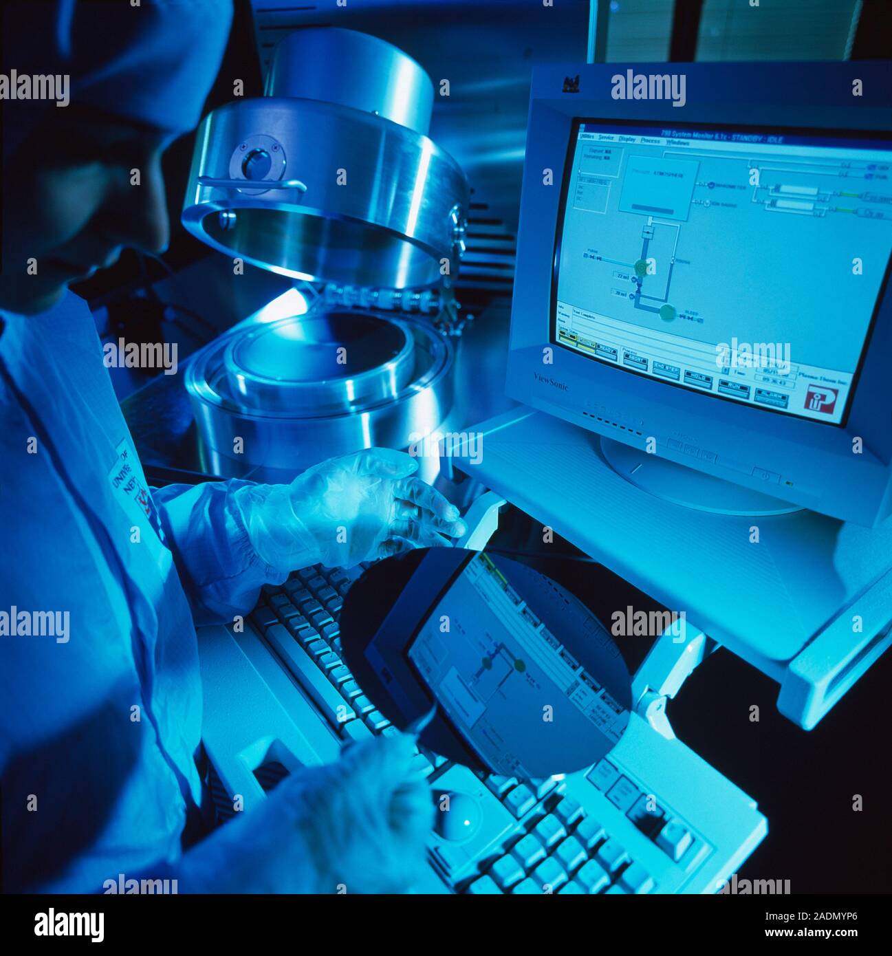 Plasma etching. Technician in clean room clothing holding a ...