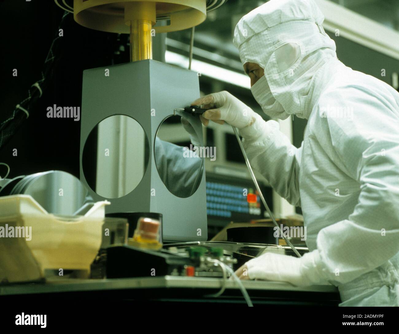 Semiconductor manufacture. Technician wearing protective clothing in a ...