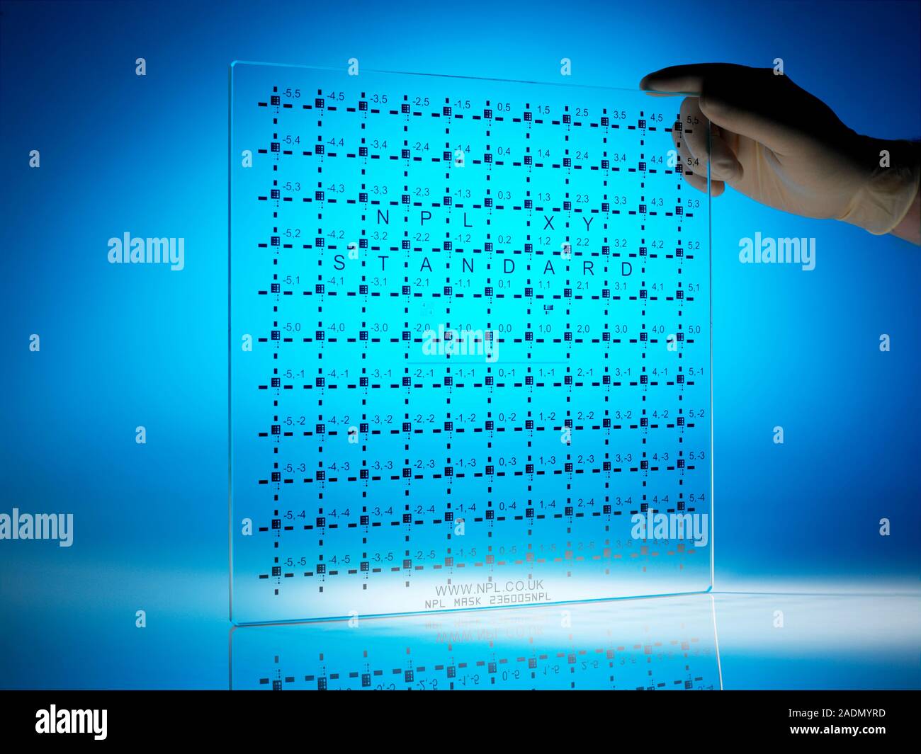 Two-dimensional calibrating standard. Physicist holding an X-Y (two ...