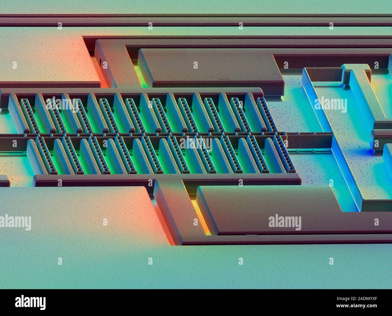 Micromechanic accelerometer. Coloured scanning electron micrograph of a ...