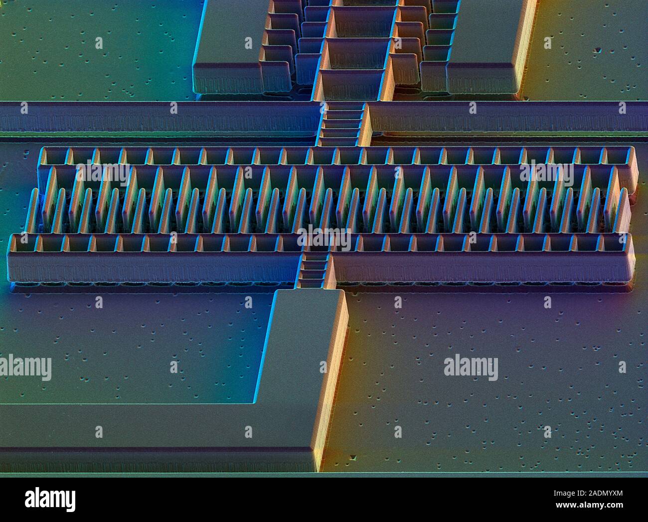 Micromechanic accelerometer. Coloured scanning electron micrograph of a ...