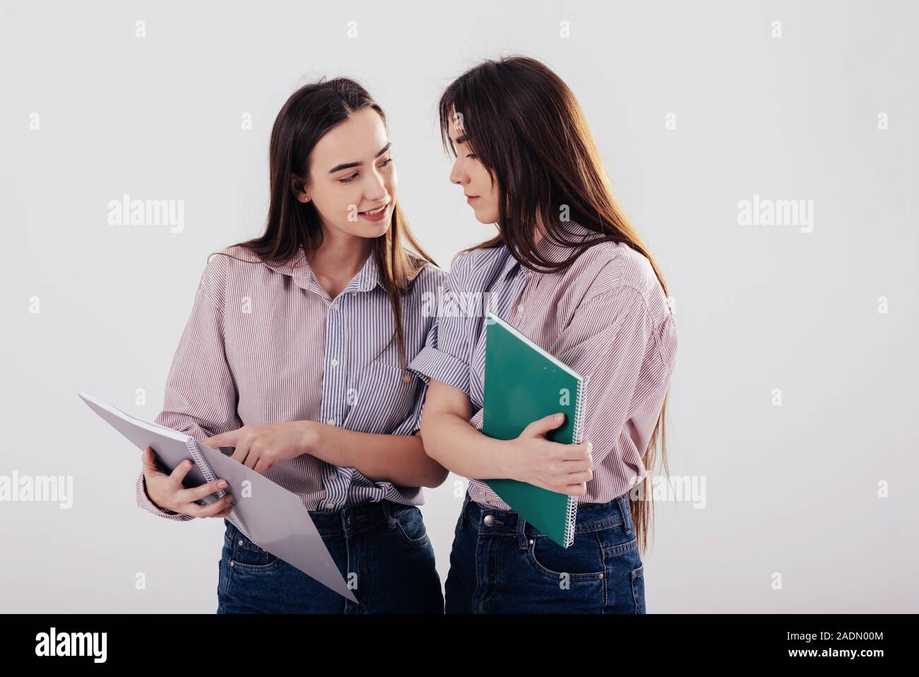 Interesting information in the notepads. Two sisters twins standing and ...