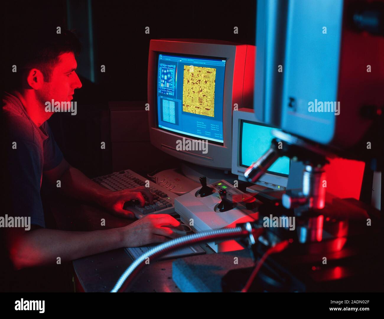 Examining microdevice. Technician inspecting a microelectromechanical ...