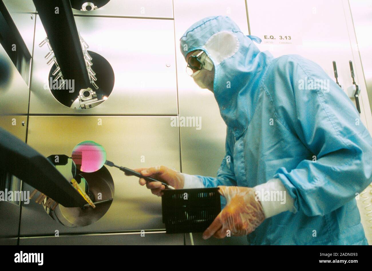 MEMS production. Clean room technician removing a silicon plate from a ...