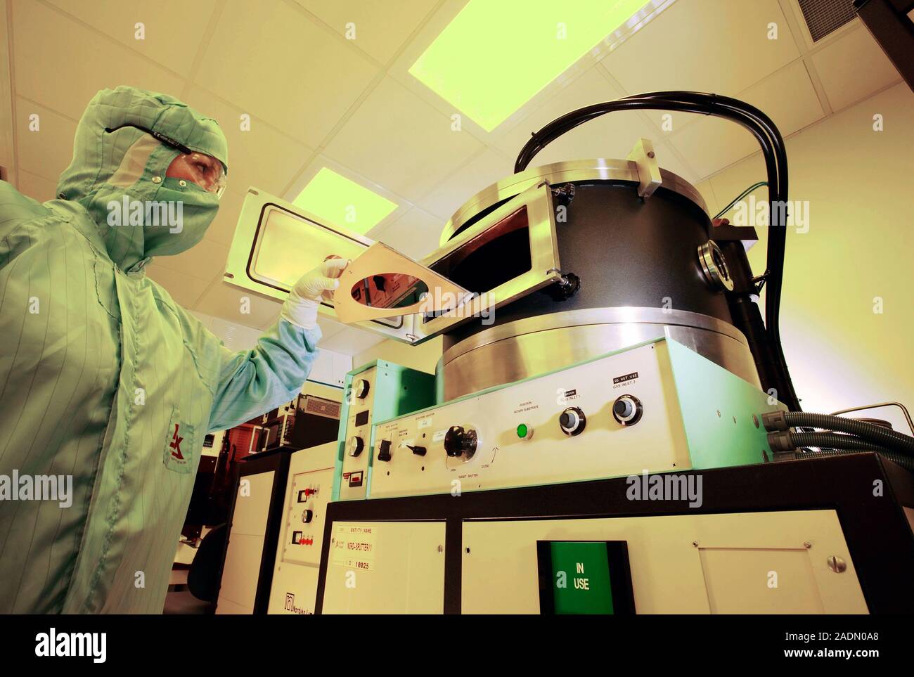 MODEL RELEASED. MEMS production. Clean room technician using a thin ...