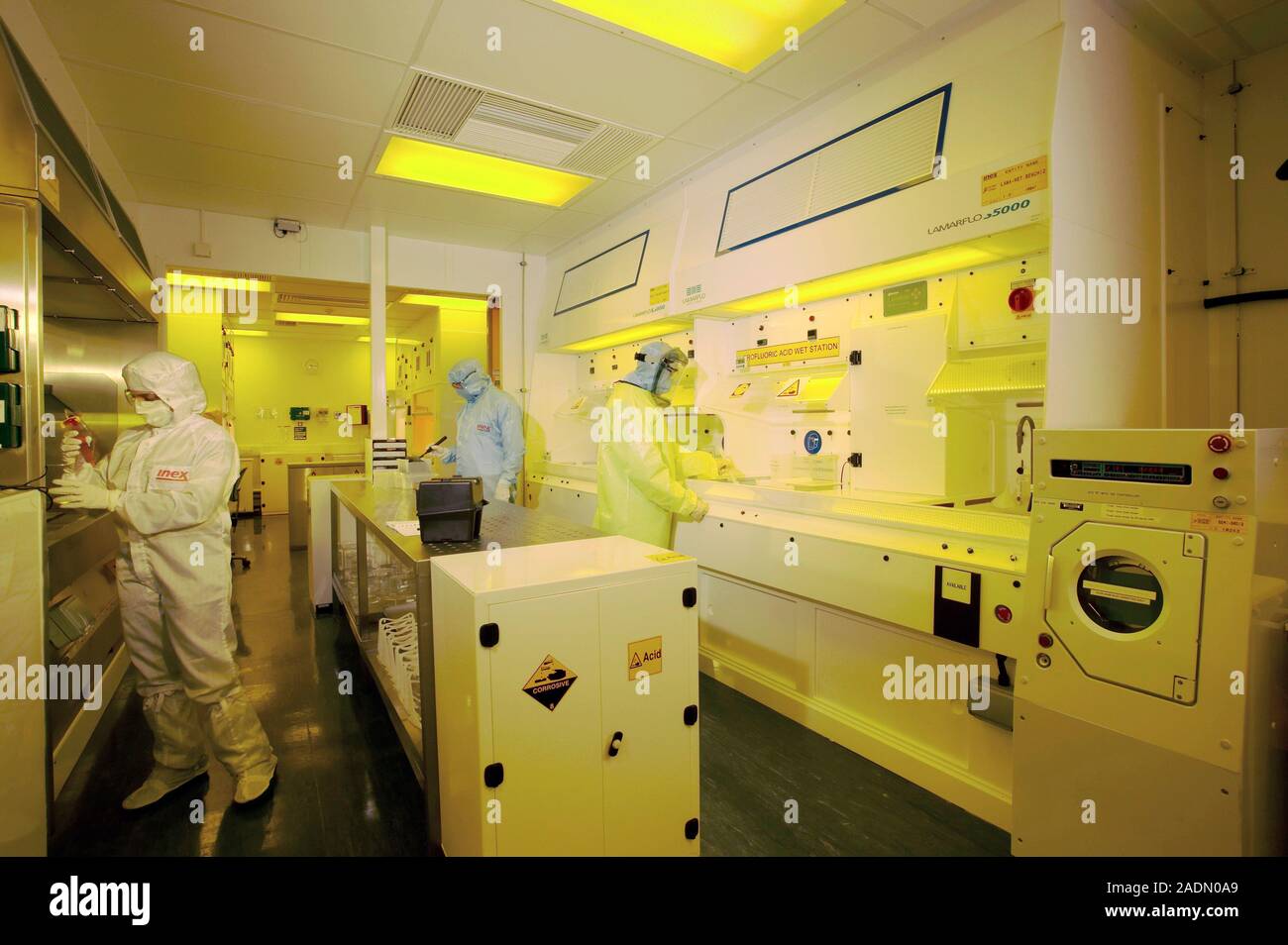 MODEL RELEASED. MEMS production. Clean room technicians using chemical ...