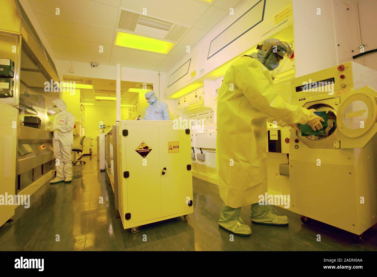 MODEL RELEASED. MEMS production. Clean room technicians using chemical ...