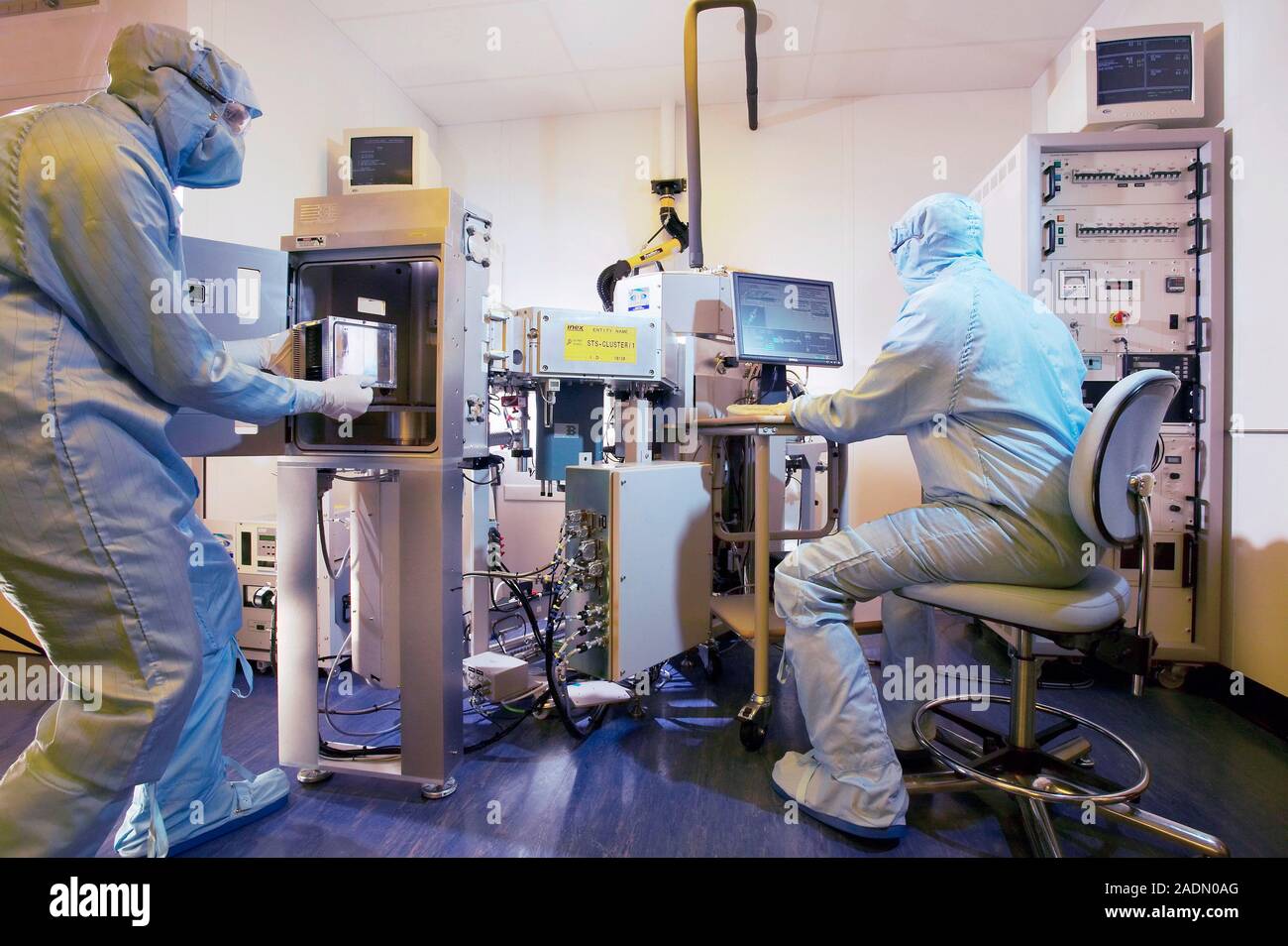 MODEL RELEASED. MEMS production. Clean room technicians using plasma ...