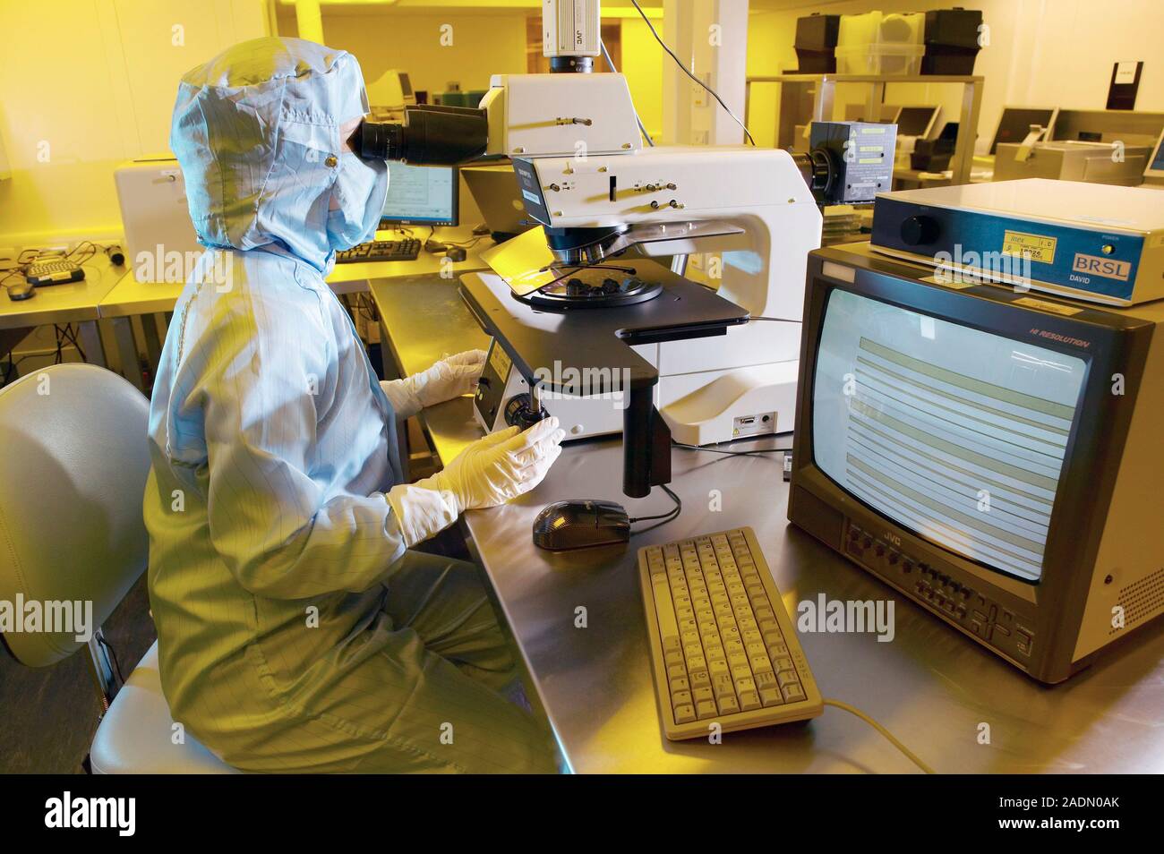 MODEL RELEASED. MEMS production. Clean room technician using a ...