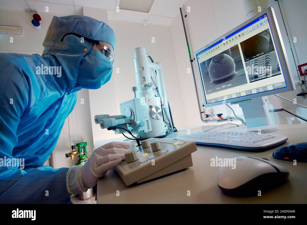 MODEL RELEASED. MEMS production. Clean room technician using a scanning ...