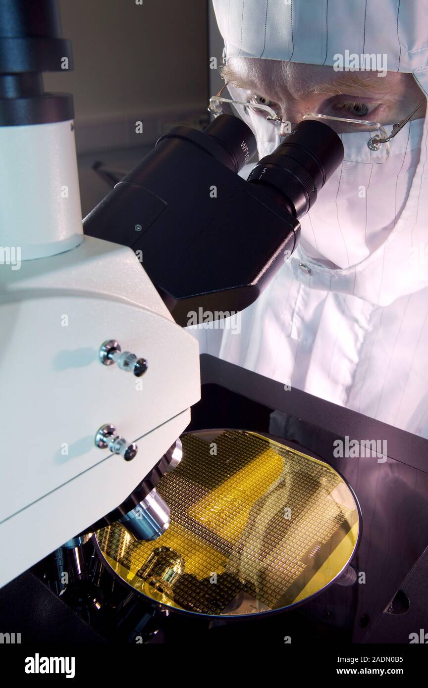 MODEL RELEASED. MEMS production. Clean room technician using a ...