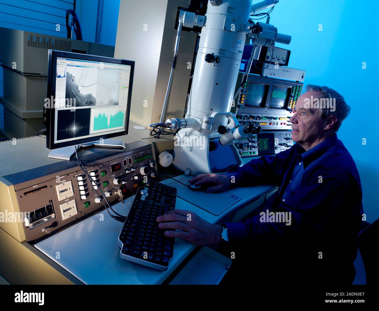 Nanoparticle research. Scientist operating a transmission electron ...