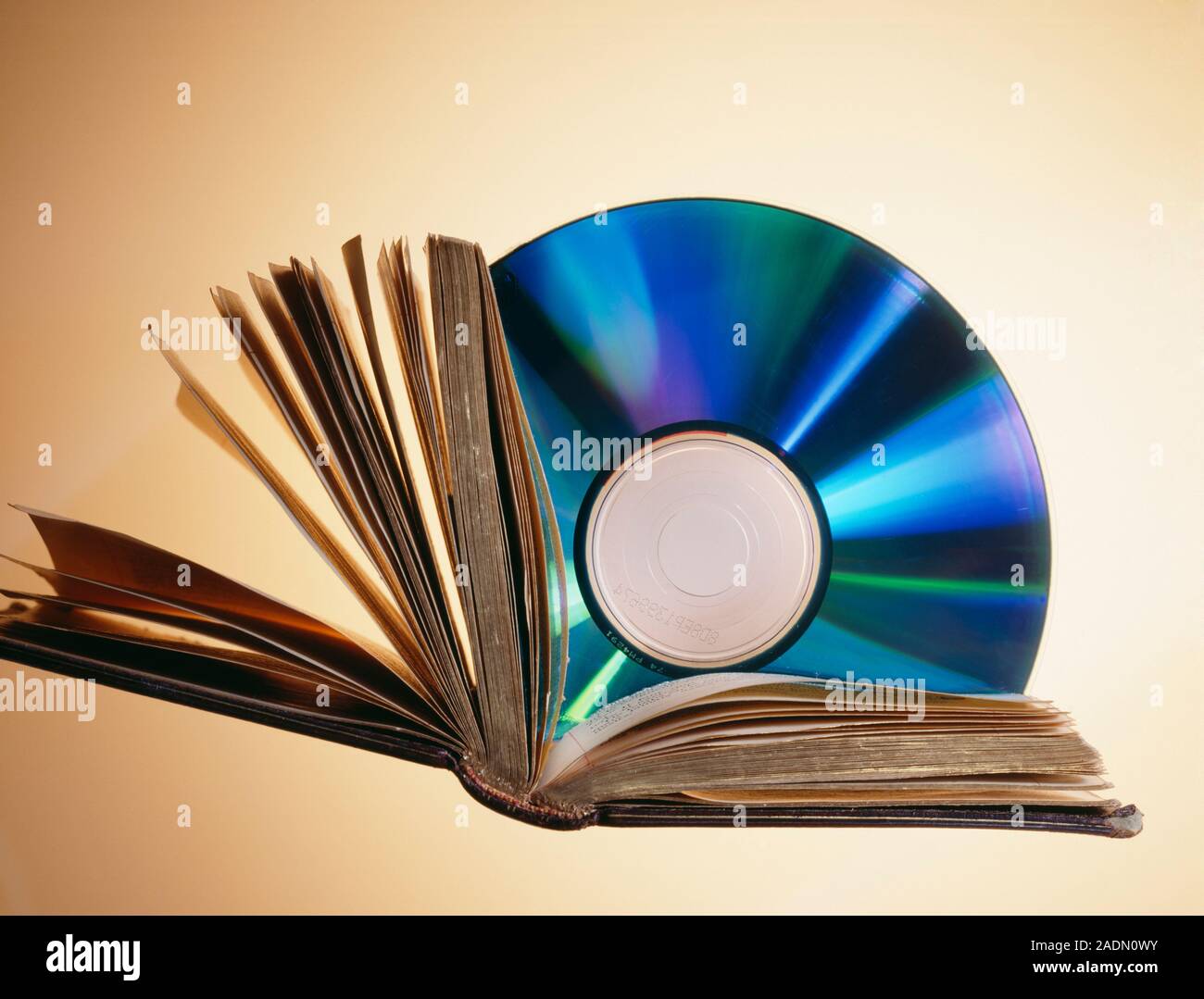CD-ROM with a book illustrating the evolution of technology and information storage Stock Photo ...