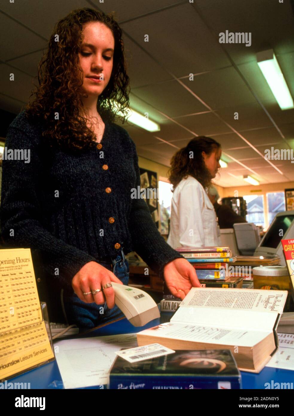 Bar code scanner. Female librarian using a hand-held scanner to read ...