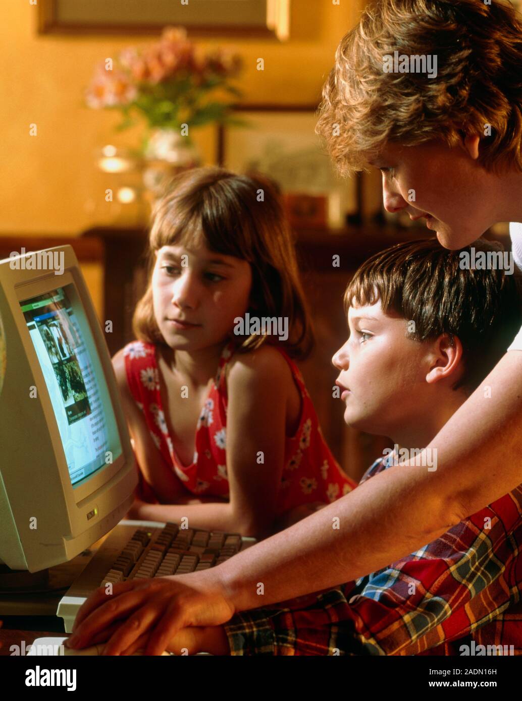 Children with computer. Mother helping her children to use a personal ...