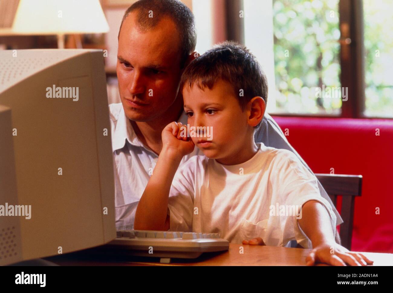 Home computing. Father and son using a personal computer Stock Photo ...