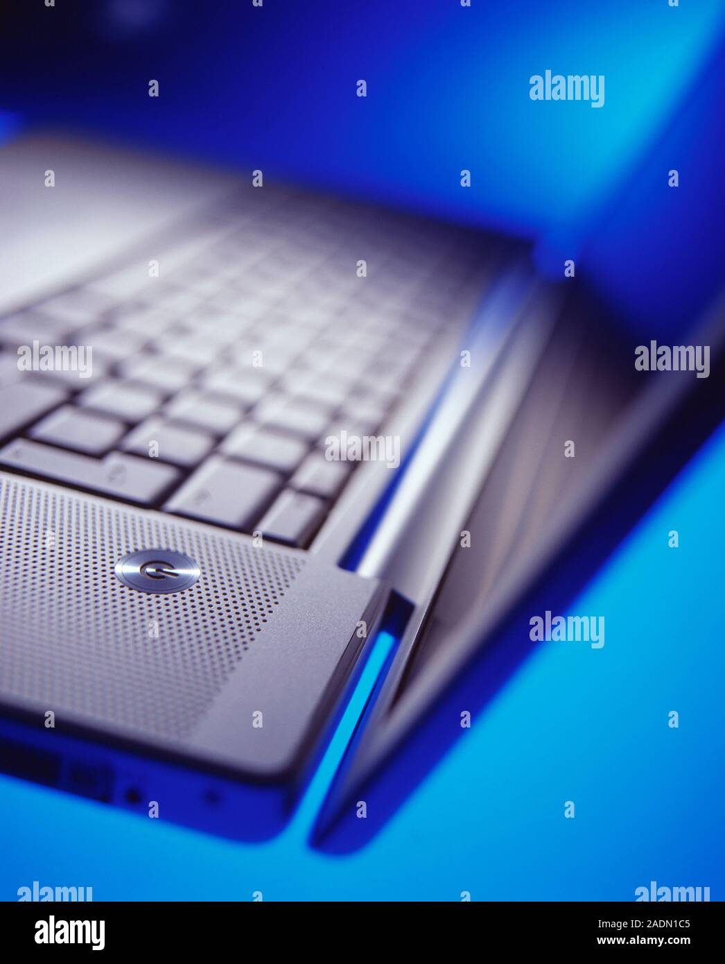 Laptop computer. Side view of the keyboard (left) and screen (right) of ...