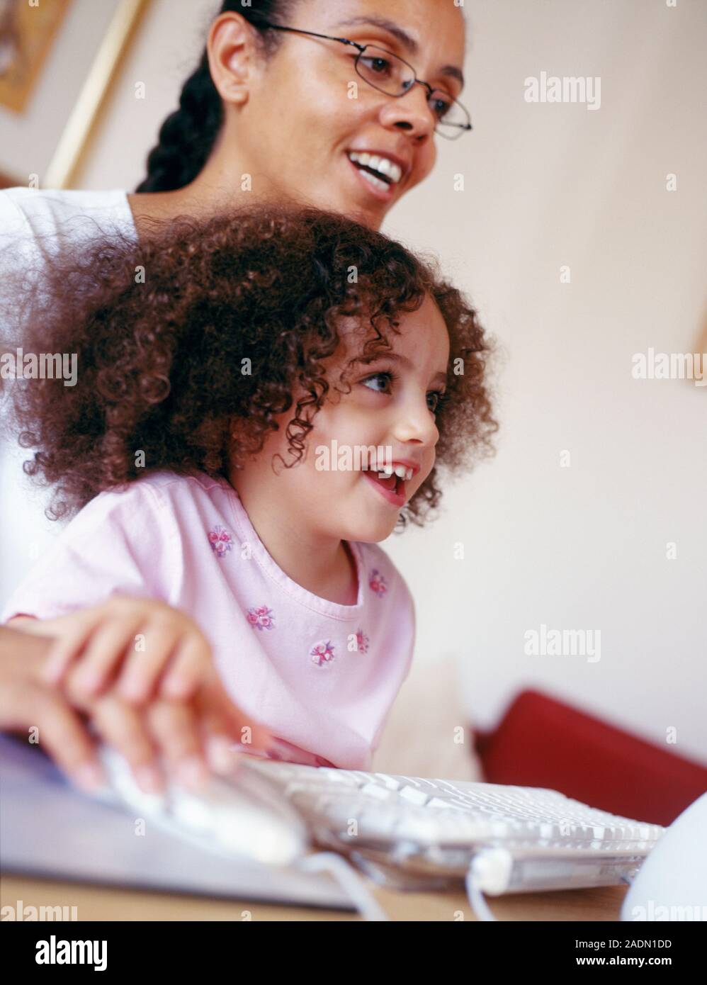 MODEL RELEASED. Computer use. Three year old girl and her mother using ...