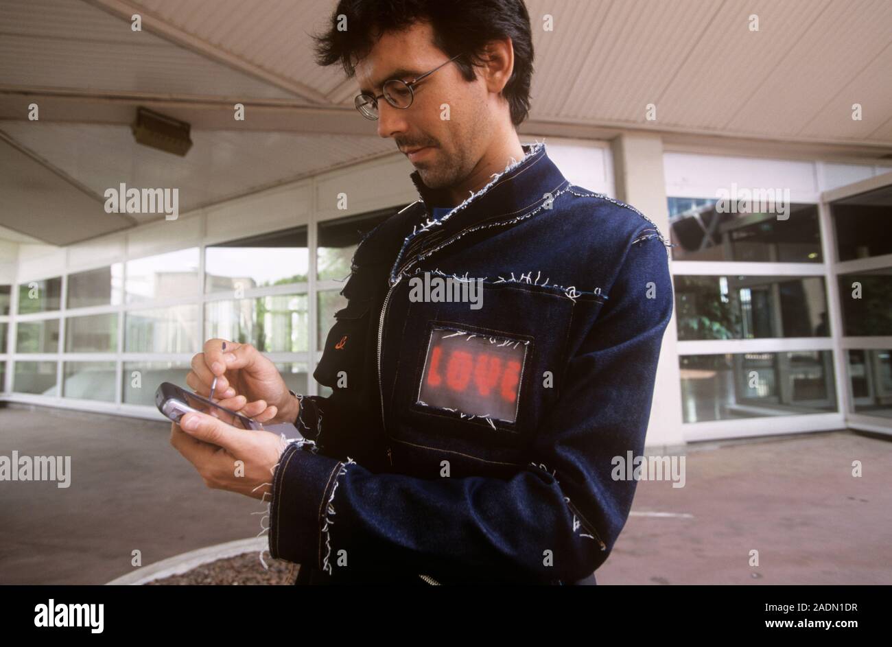 Computerised clothing. Researcher from France Telecom programming a ...