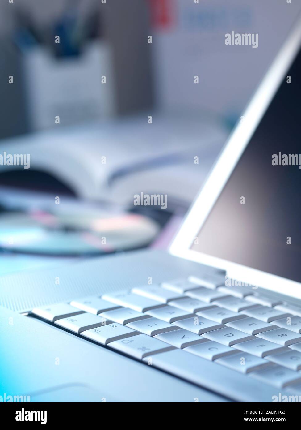 Laptop on a desk beside a compact disc (CD) and an open book Stock ...