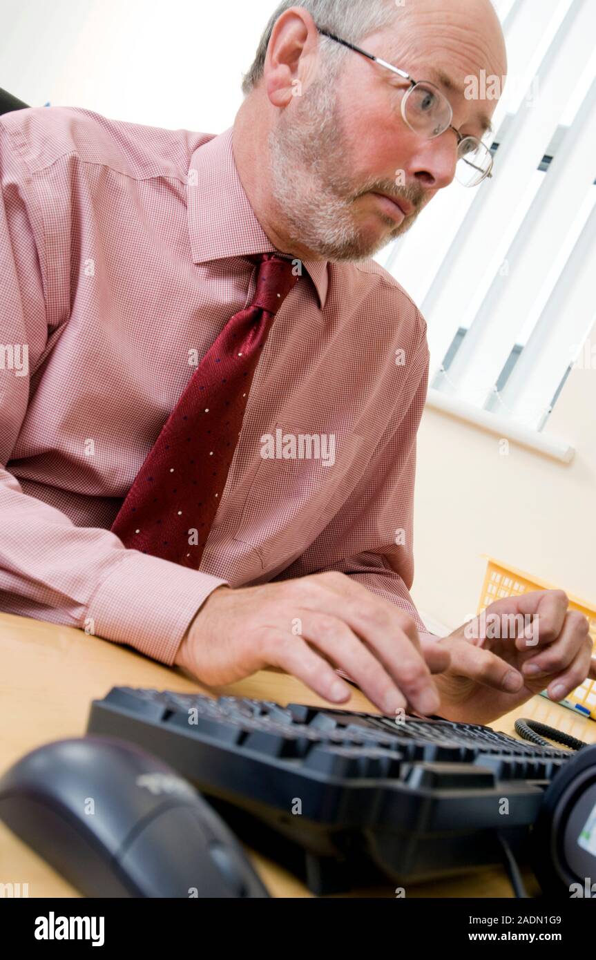 MODEL RELEASED. Computer use. Man typing on a computer keyboard ...
