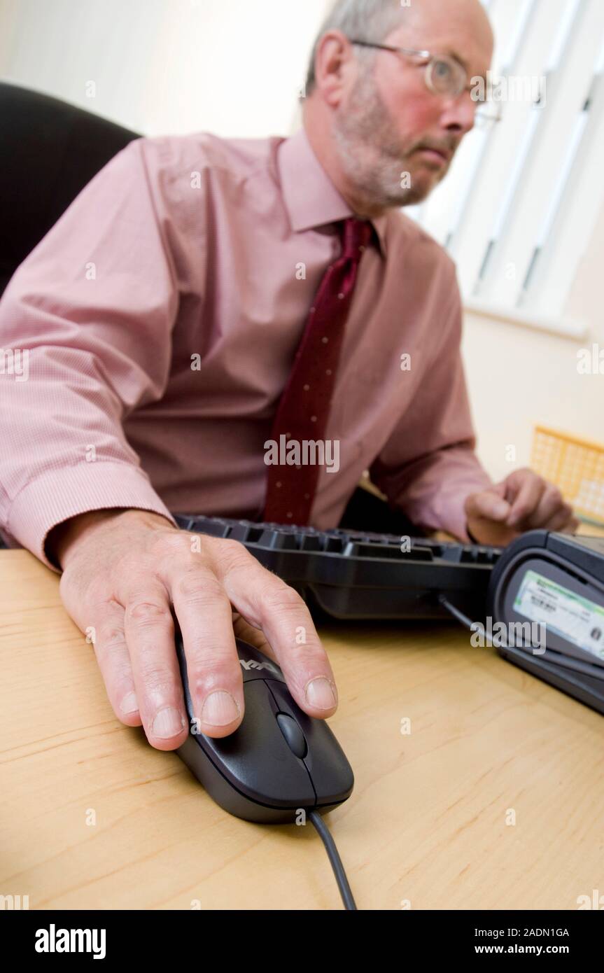 MODEL RELEASED. Computer use. Man typing on a computer keyboard ...