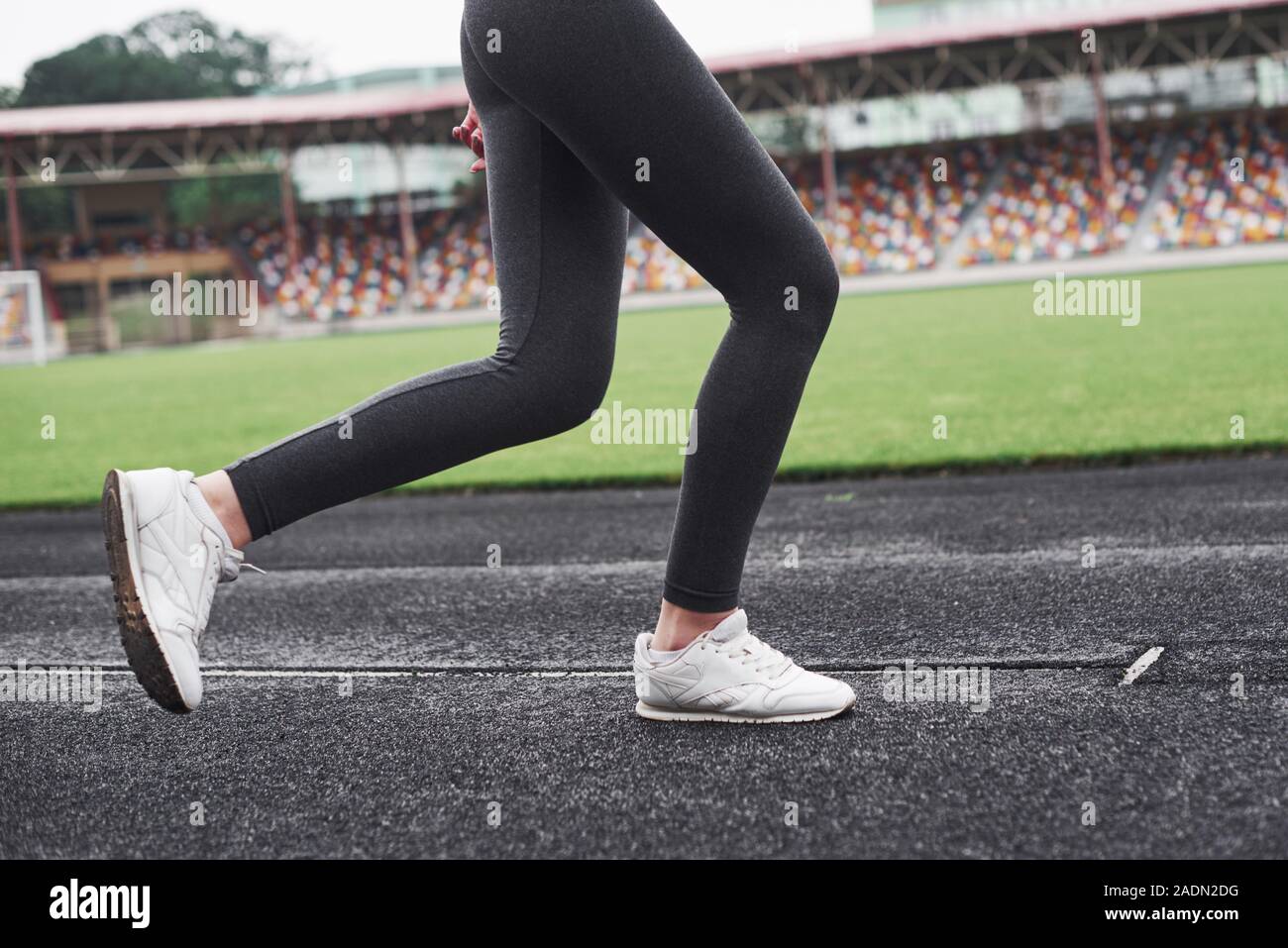 Picture of the legs only. Girl running on the track in the stadium at ...